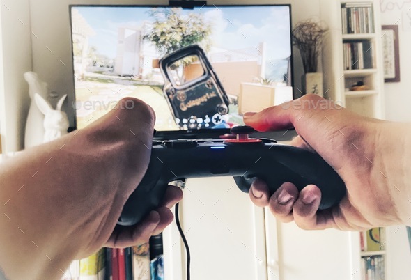 First person shooter game holding controller Stock Photo by dabobabo