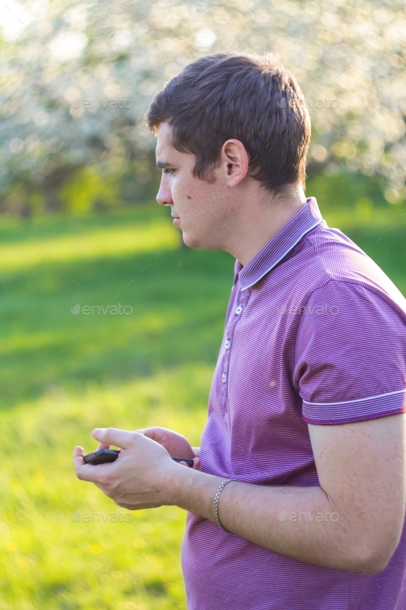 Defocus pleasant cheerful handsome young man holding phone. Profile ...