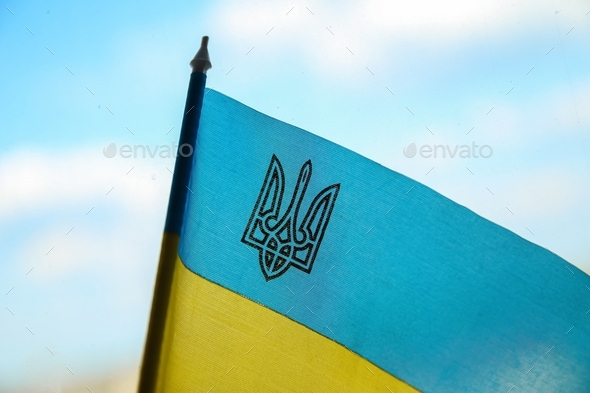 Ukraine flag. Closeup trident. National symbol fluttering in blue sky ...