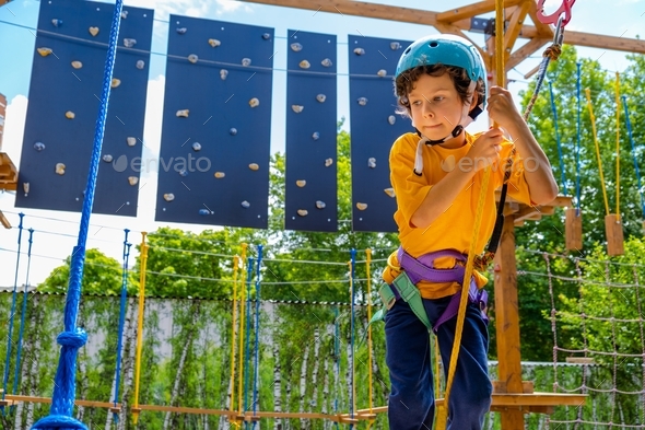 boy crossing an Course High Ropes Element in Adventure park Outdoor ...