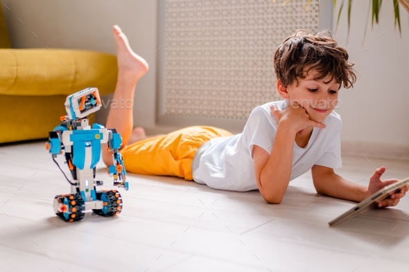 Kid programming robot from plastics details and programmed on tablet ...