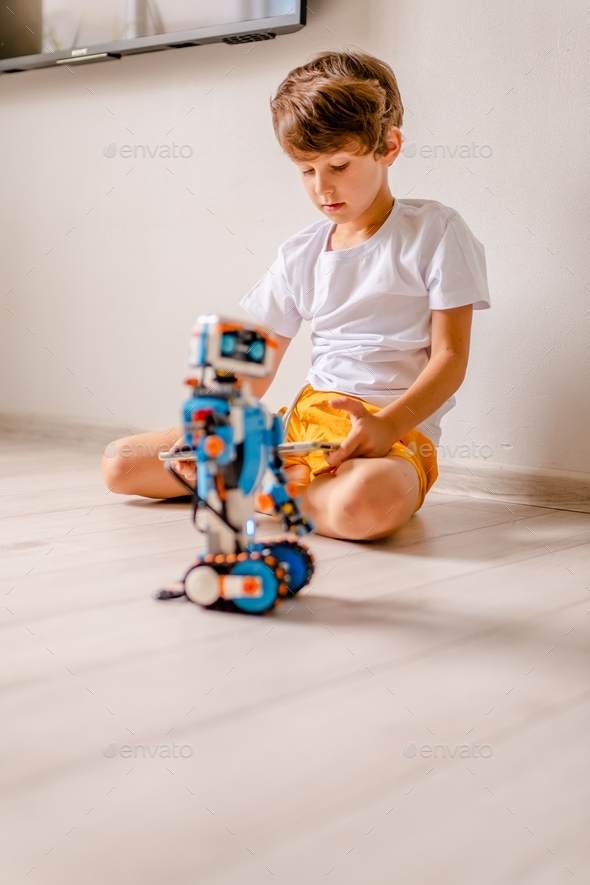 Kid programming robot from plastics details and programmed on tablet ...