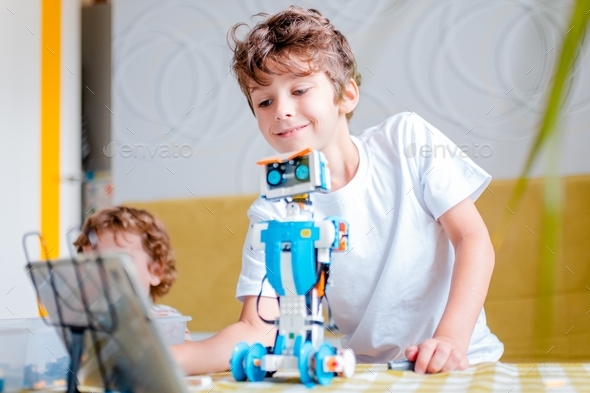 Kid programming robot from plastics details and programmed on tablet ...