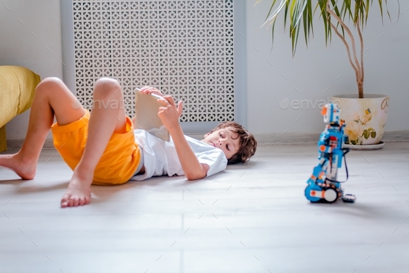 Kid programming robot from plastics details and programmed on tablet ...