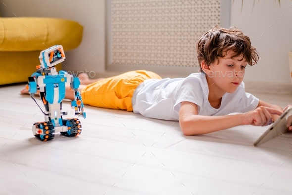 Kid programming robot from plastics details and programmed on tablet ...