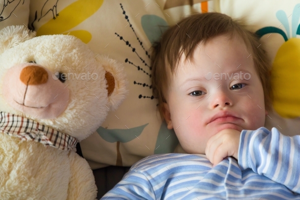 Baby boy with Down syndrome and his teddy bear Stock Photo by TDyuvbanova