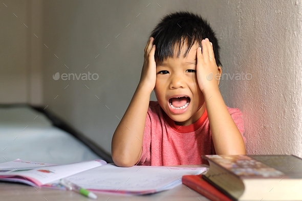 Asian student child boy have a headache and stressed when he get many ...