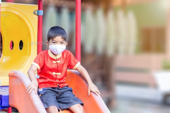Happy Asian child boy wearing fabric mask, He playing with slider bar ...