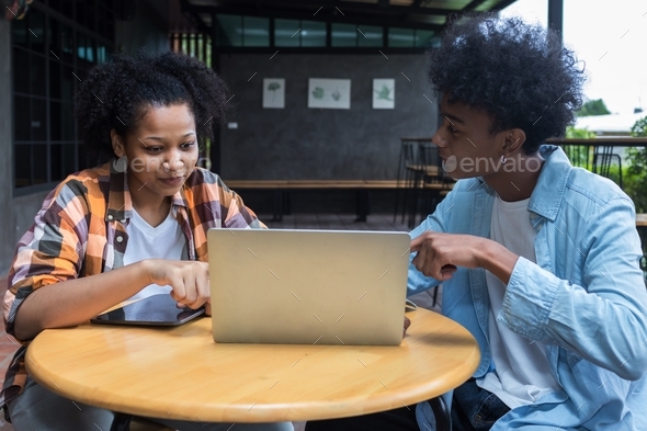 Student Life. Two students in school and working on laptop, checking ...