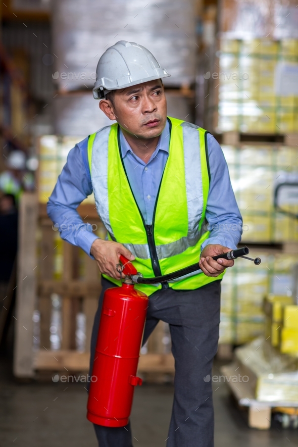 Foreman or worker holding a fire extinguisher and ready stop fire in ...