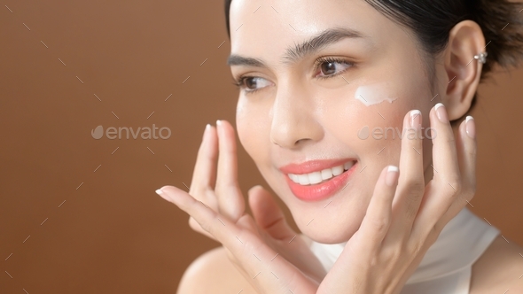 A young woman with beautiful face using cream of her face Stock Photo ...