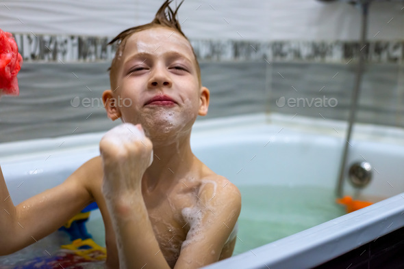 Personal hygiene, lifestyle portrait of a red-haired boy washing ...