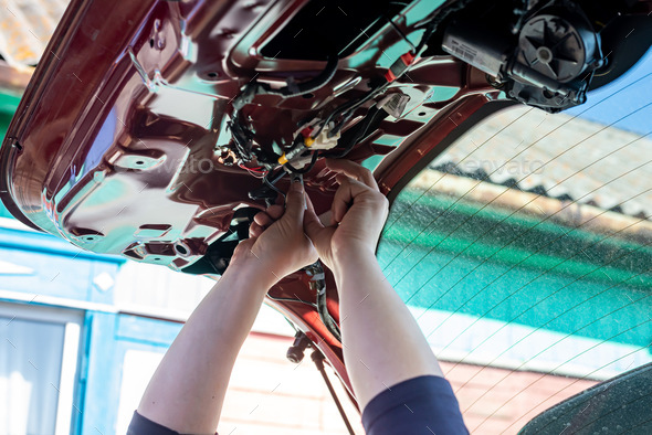 Hands of a man repairing a car by himself. Repair work. Mechanic. Trunk ...