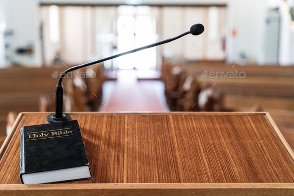 Bible on church pulpit, with light coming through the front doors Stock ...
