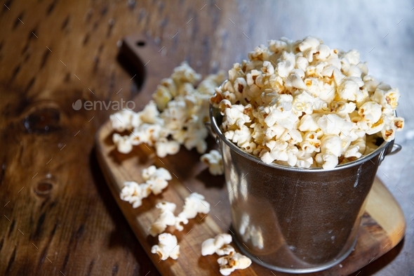freshly popped popcorn on bench in tin container, popped and ready to ...