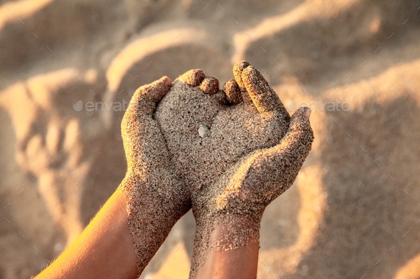 Hands holding sand, kid playing with sand at the beach, childhood and ...