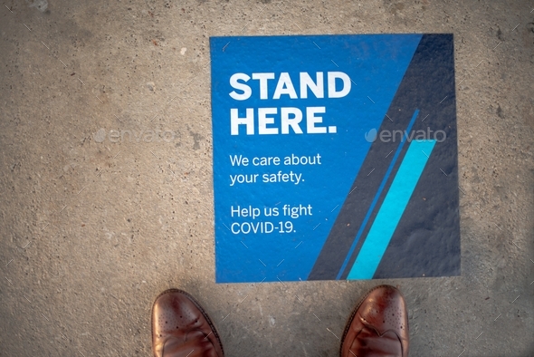Stand here sign informing clients to keep social distance during COVID ...