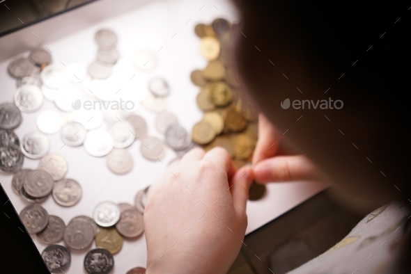Checking and inspecting different coins, searching for a rare coin ...