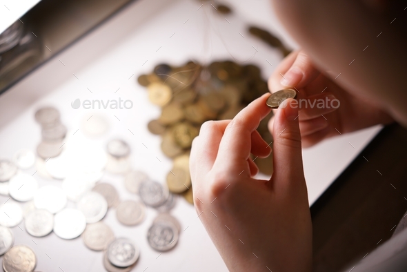 Checking and inspecting different coins, searching for a rare coin ...