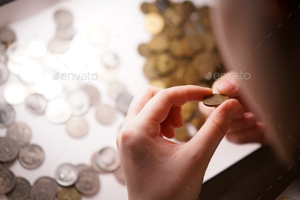 Checking and inspecting different coins, searching for a rare coin ...