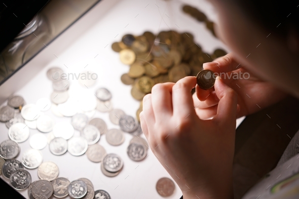 Checking and inspecting different coins, searching for a rare coin ...