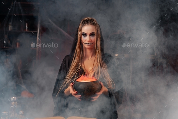 Halloween, witch use magic book and cauldron prepare poison or love ...
