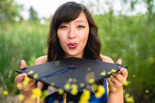Recent college graduate posing for the camera in cap and gown ...