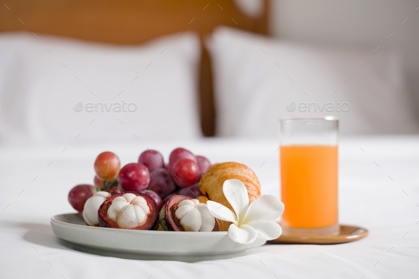 Focus on fruit. In a hotel room with fruit, place a tray on the bed to ...