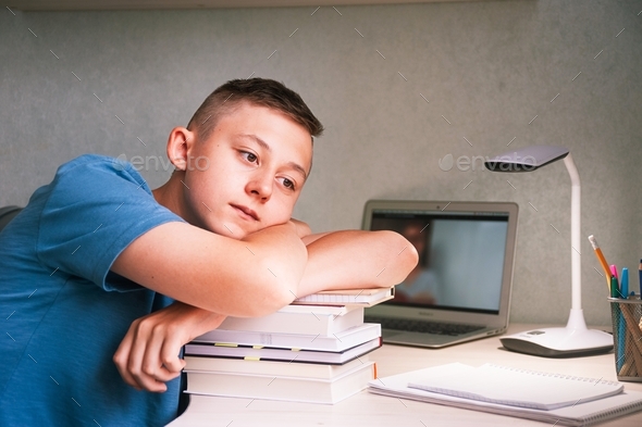 Teen boy napping on a stack of books. Learning fatigue. Back to school ...