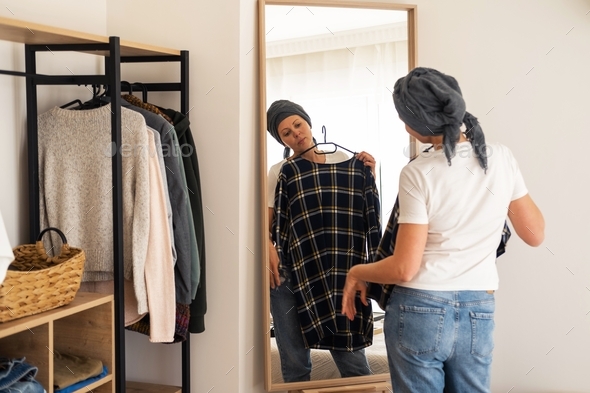 A woman is sorting through clothes in her wardrobe. Stock Photo by ...