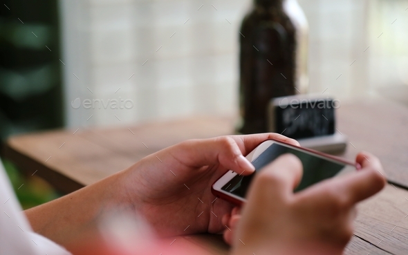 People hand using mobile phone closeup interior blur background ...