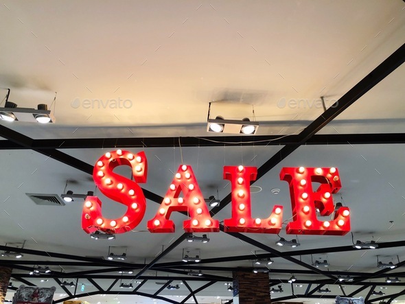 Big red "SALE" sign with light bulbs decoration i shopping mall closeup ...