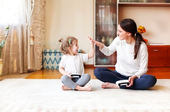 Delighted woman and girl with gamepads smiling and doing high five ...