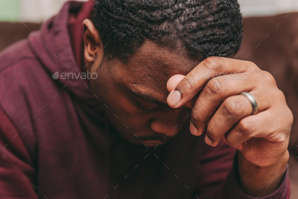 African man at home looking sad and depressed Stock Photo by R_Hamilton