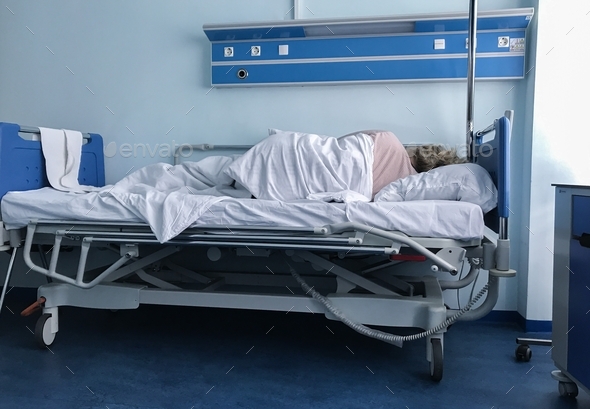 Hospital room. A patient is sleeping on the bed facing the wall Stock ...