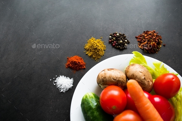 Plate with fresh vegetables: potatoes, tomatoes, carrots and herbs ...
