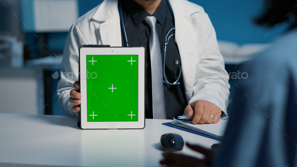 Practitioner doctor holding tablet computer pointing at green screen ...