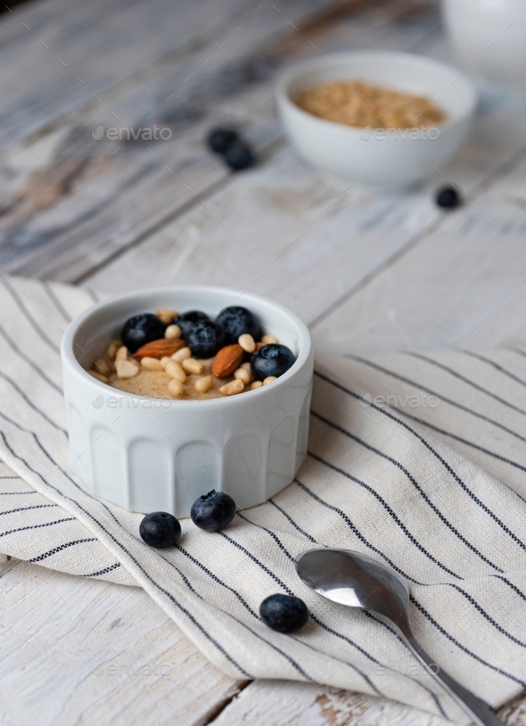 Oat meal porridge with blueberry, nuts. Stock Photo by alinanikitaeva