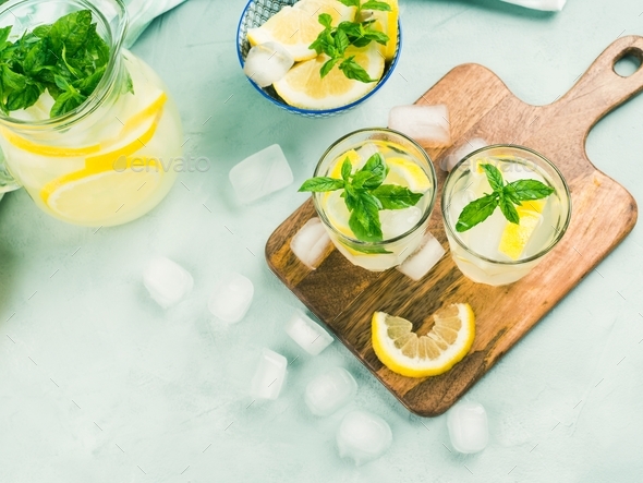 Summer cold lemonade drink with lemon and mint leaves, ice cubes Stock Photo by tenkende