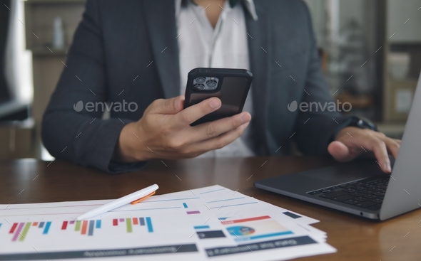 Business people use smartphone and working on desk with paper graph and ...