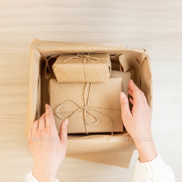 Unpacking a box with parcels in kraft paper and tied with twine ...