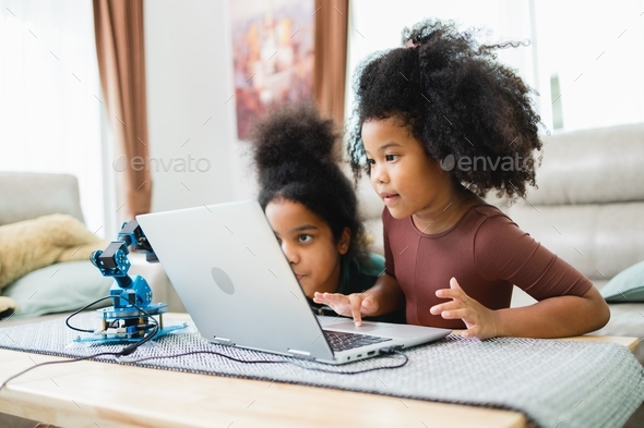Two African American girls learned robot arms with a program computer ...