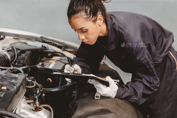 Woman garage worker maintenance checklist at automobile service center ...