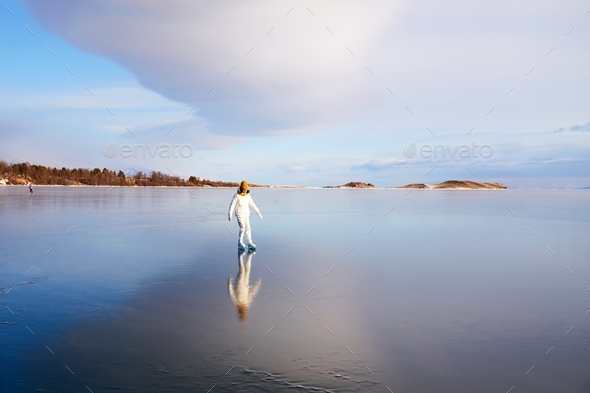 A natural skating. A young girl is skating on the transparent ice of ...