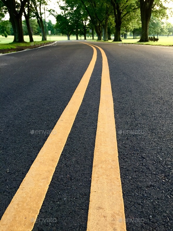 Low angle view of an open winding road through a park. Stock Photo by ...