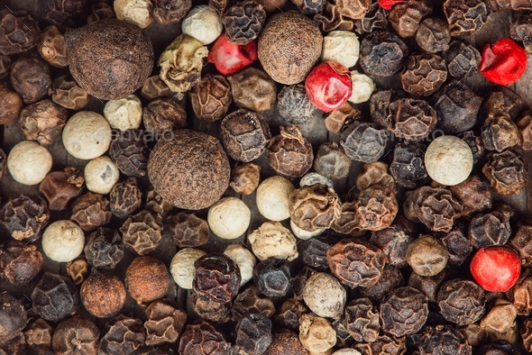 Peppers hot, red, black, white and gray grains as background. Close up ...