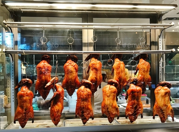 many roasting ducks on rotisserie spits in the Chinese restaurant ...