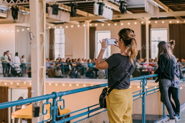 Event venue. Woman taking a picture of an event venue with her mobile ...