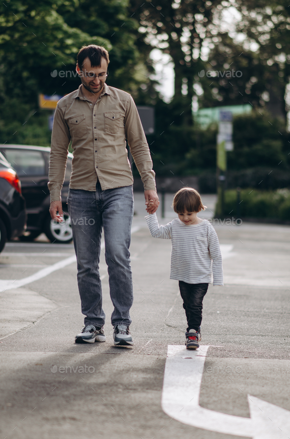 A boy with his dad follows a painted arrow on the asphalt Stock Photo ...