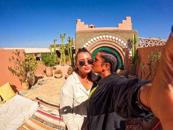 LGBTQ cute lesbian gay couple kiss on cheek in riad in Marrakech ...